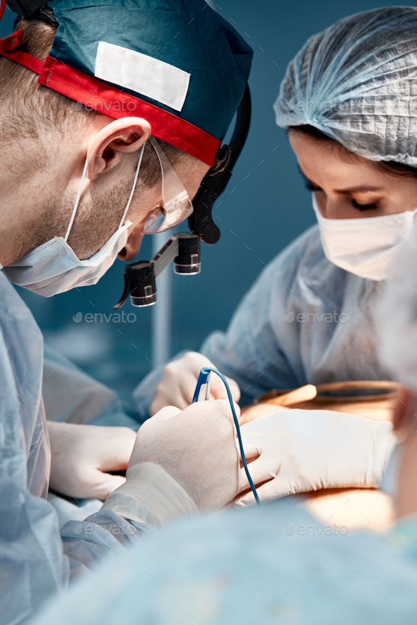 Surgeon assistant feeds coagulator, plastic surgery, professional ...