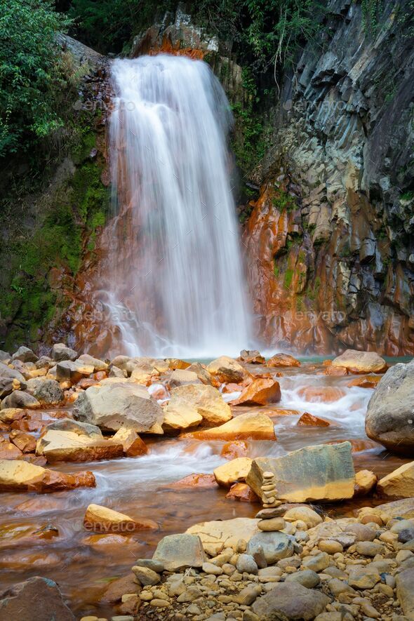 Red Rocks waterfall cascading over a rugged landscape of rocks in ...