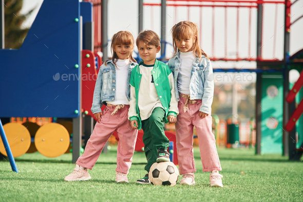 One boy and two girls. Kids are having fun on the playground Stock ...