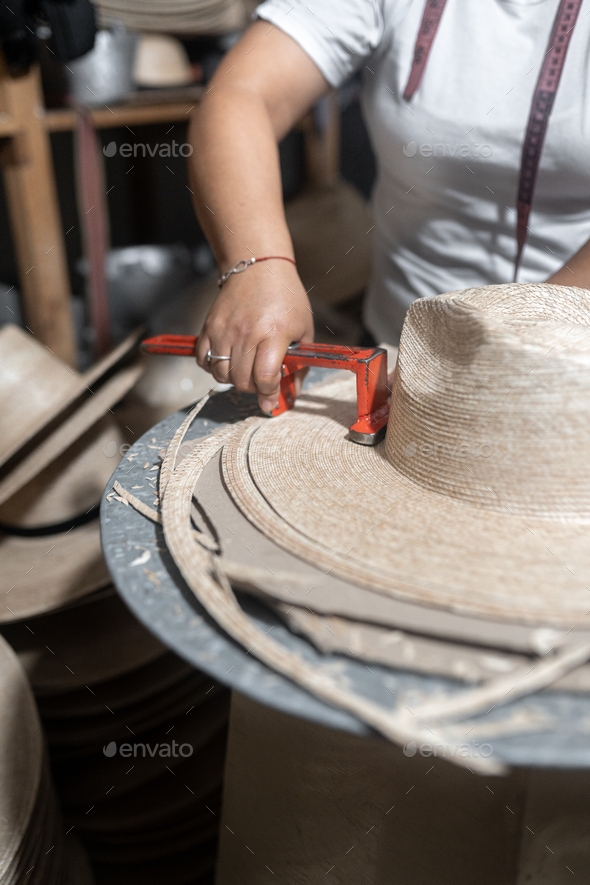 Cutting the brim of a traditional natural fiber hat Stock Photo by ...