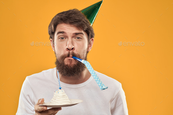 Handsome man with a beard and in a cap celebrating a birthday party ...