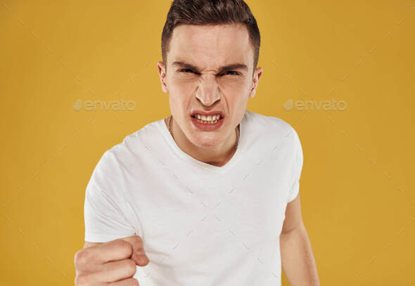 Angry man on a yellow background cry of emotion and stress Stock Photo ...