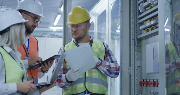Three Electrical Workers Reviewing Documents, Stock Footage | VideoHive