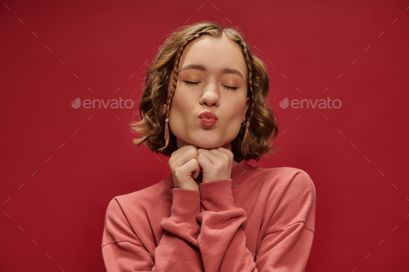 portrait of young pretty woman with short wavy hair and braids pouting ...