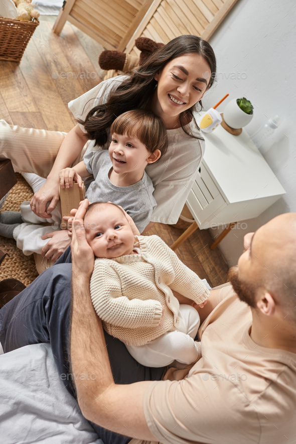 vertical shot of happy family in cozy homewear spending time together ...