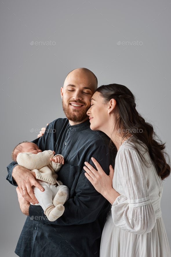 vertical shot of beautiful parents in classy outfits hugging and ...