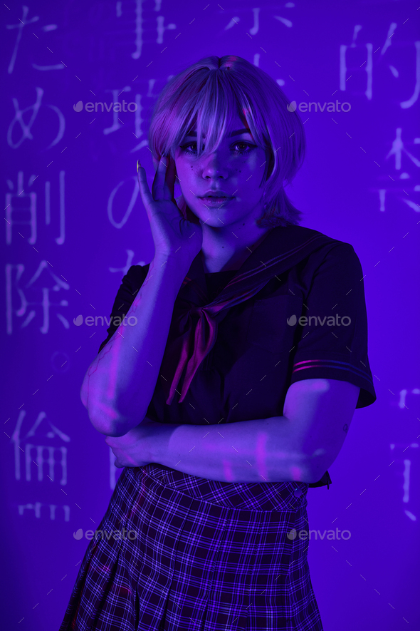 woman in blonde wig and school uniform in blue neon light with ...