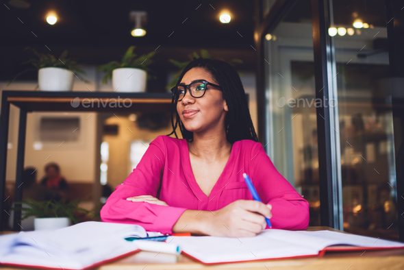 Black female writer with notebooks in cafe Stock Photo by GaudiLab