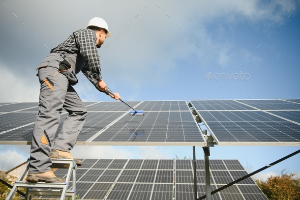 technician operating and cleaning solar panels at generating power of ...