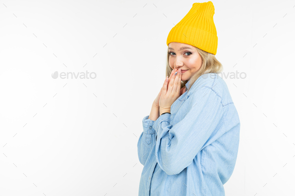 close-up of an embarrassed cute girl in a blue denim jacket on a white ...