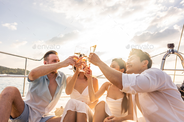 Group of diverse friend sit on deck of yacht while yachting together ...