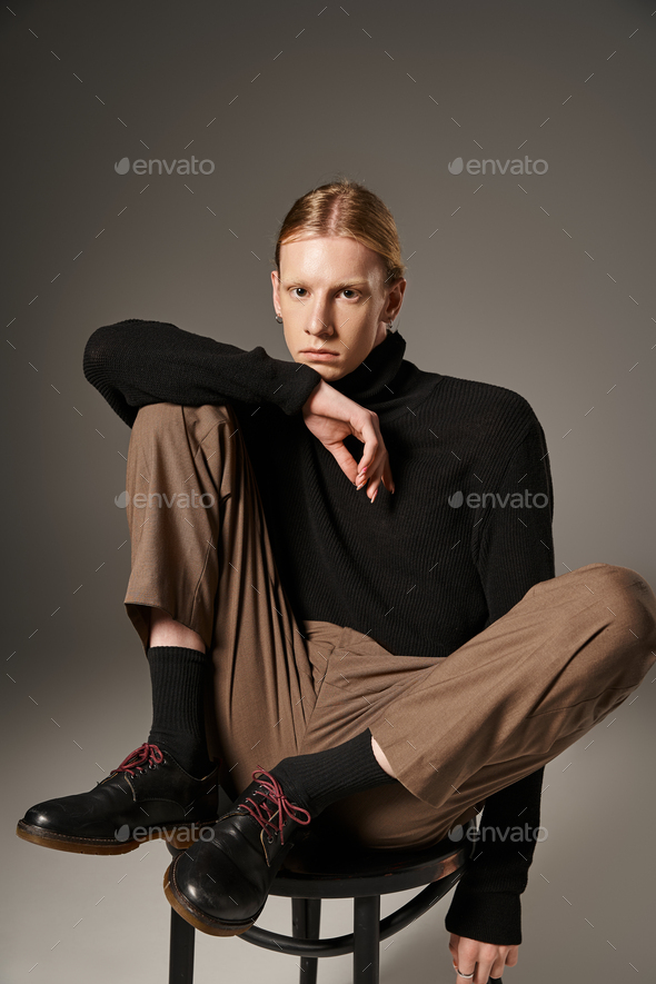 vertical shot of young non binary model in stylish attire posing on ...