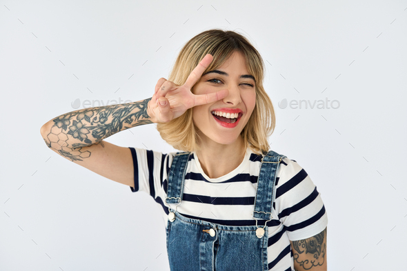 Happy gen z blonde girl showing peace sign over face isolated on white ...