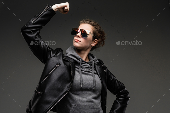 A young girl with rough facial features in a black jacket shows her ...