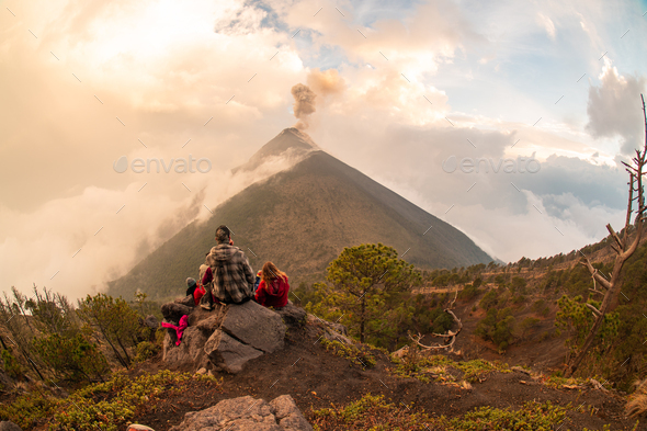 two people sitting on a large rock in the air with a view of the ...
