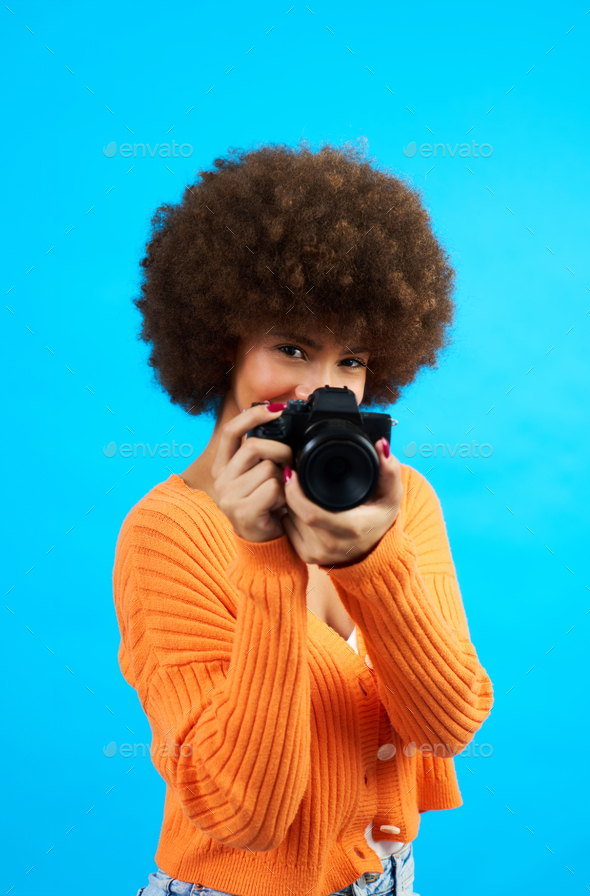Portrait of a photographer covering her face with her camera while ...