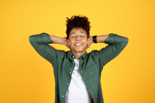 Well-rested young black guy posing with arms behind head Stock Photo by ...