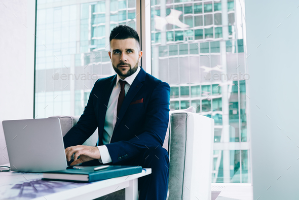 Classy executive male in suit working with laptop Stock Photo by GaudiLab