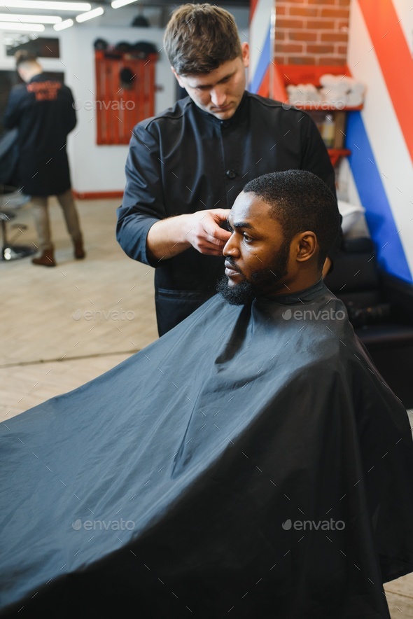 Visiting barbershop. African American man in a stylish barber shop ...