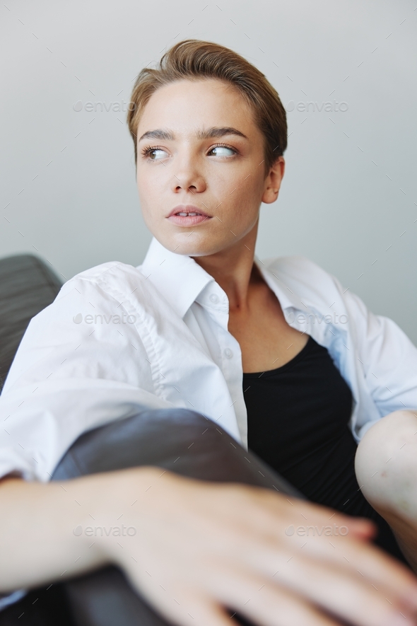 Women lying at home on the couch portrait with a short haircut in a ...