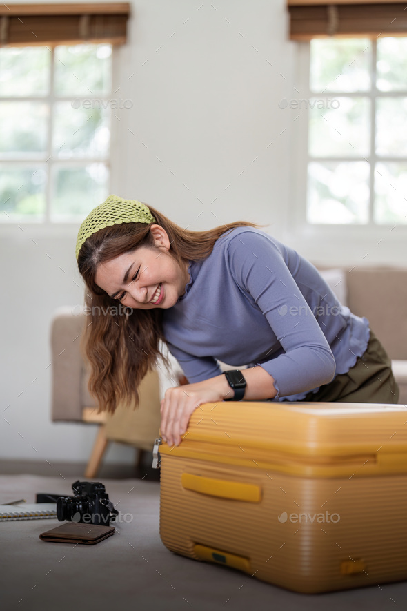 Beauty asian traveler woman packing prepare stuff and outfit clothes in ...
