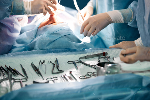 Hands of a team of surgeons close-up in the operating room during the ...