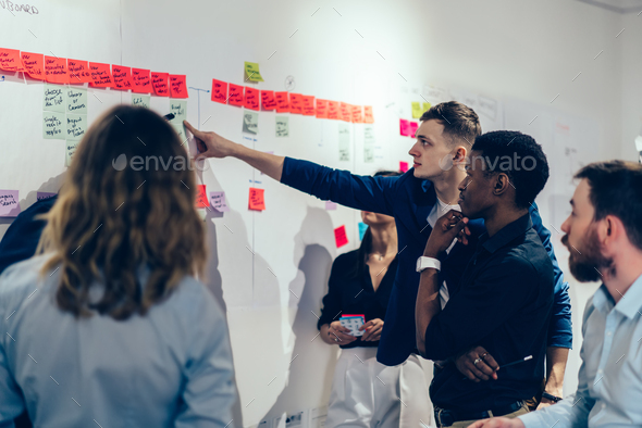 Group of creative multiethnic business people discussing strategy with ...