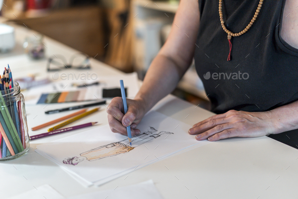 High angle of a fashion designer drawing a fashion sketch with colorful ...