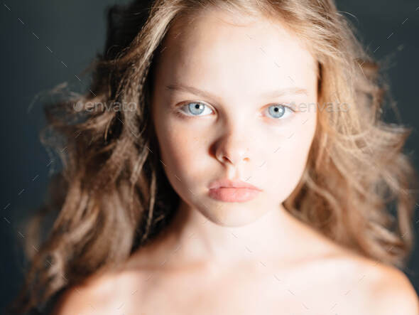 Cute little girl naked shoulders dark background beautiful face close ...