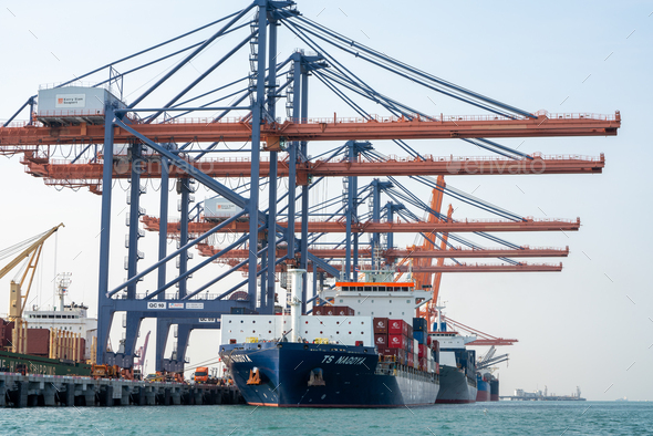 crane loading cargo container from truck to container ship in the ...