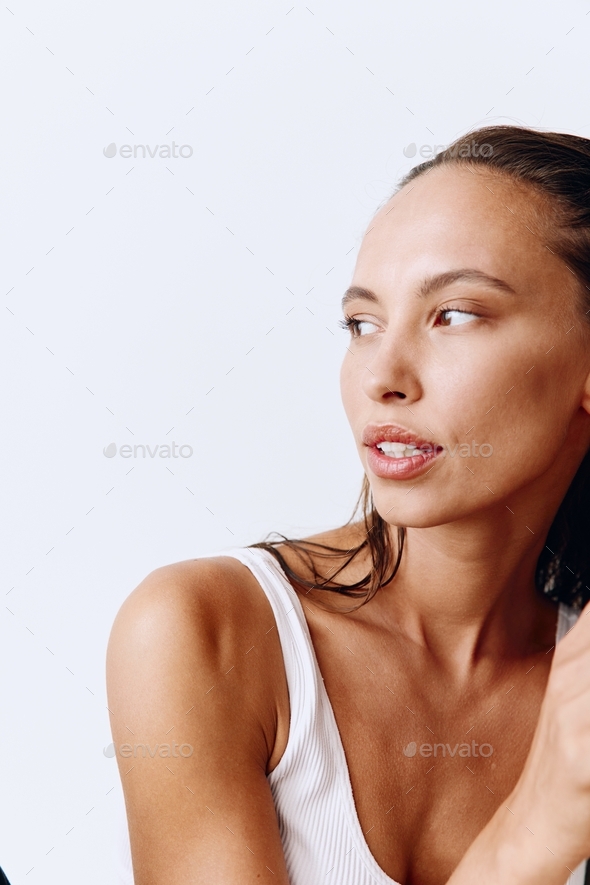 Portrait of a tanned woman looking into the camera with clear skin on ...