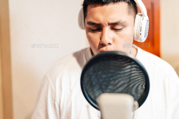 Singer using microphone and headphones recording in a home studio Stock ...
