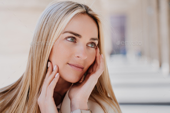Attractive Caucasian Blonde Woman Touches Face With Perfect Skin Looks