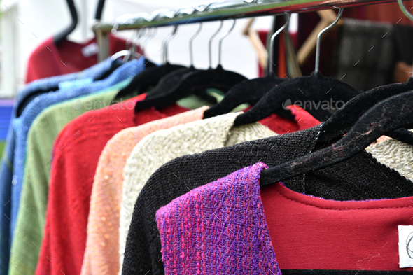 Preowned clothes hanging on hangers at a thrift store, used clothing ...