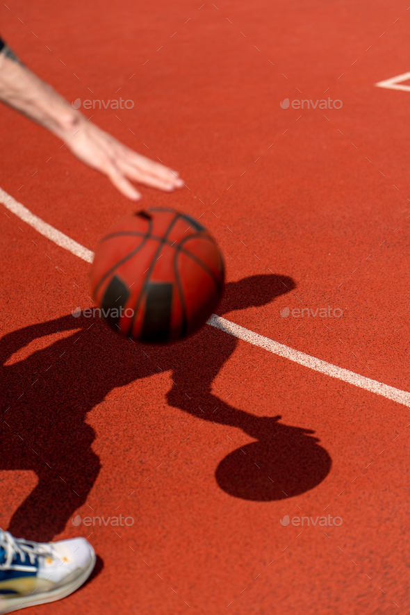 Close-up of basketball guy's shadow on the floor of a basketball court ...