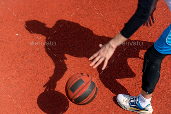 Close-up of basketball guy's shadow on the floor of a basketball court ...