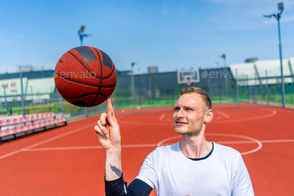 Close-up of guy basketball player spinning a basketball on his finger ...