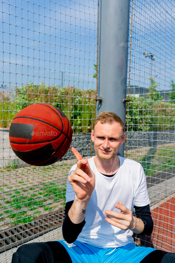 Close-up of guy basketball player spinning a basketball on his finger ...