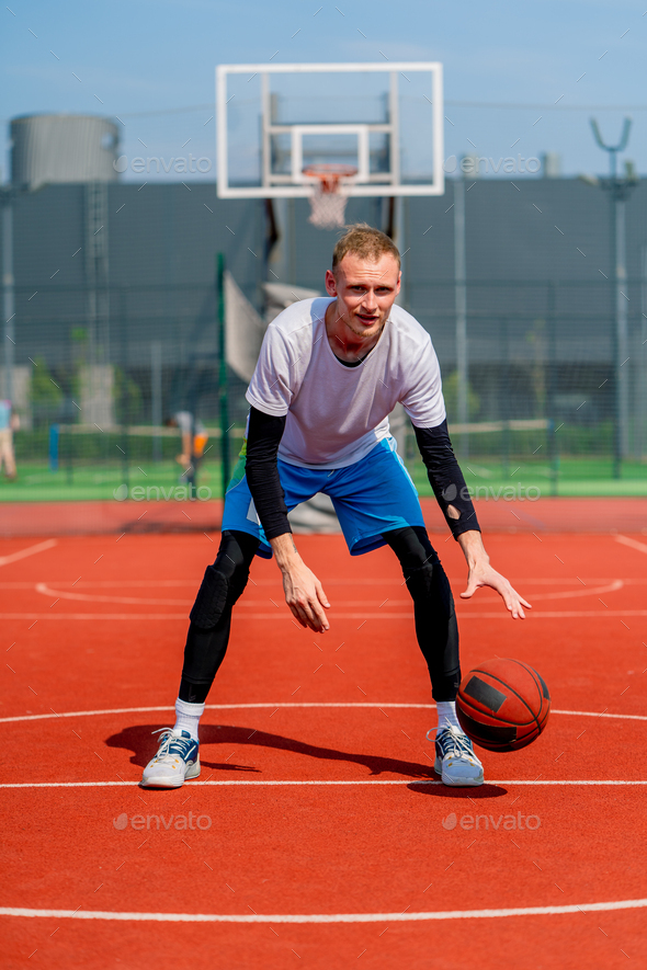 Tall guy basketball player with the ball shows his dribbling skills ...