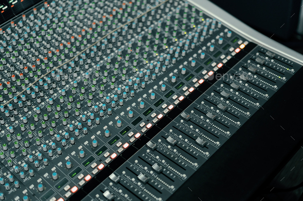 A recording studio control panel mixer with an equalizer faders buttons ...