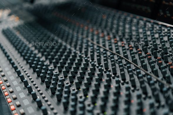 A recording studio control panel mixer with an equalizer faders buttons ...
