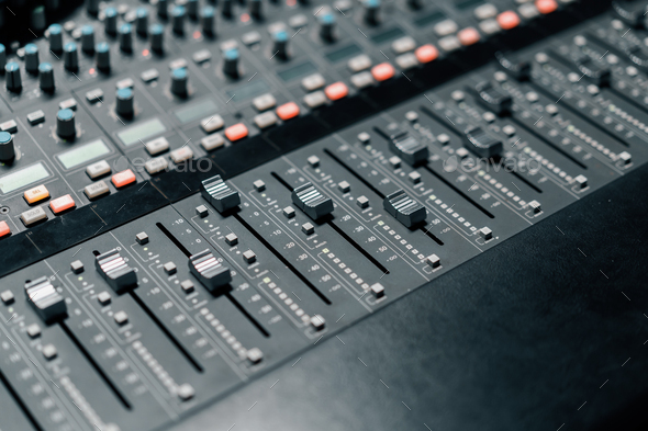 A recording studio control panel mixer with an equalizer faders buttons ...