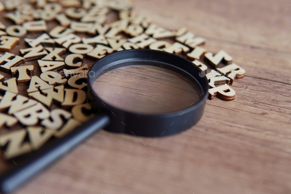 Magnifying glass with scattered alphabet letters on the table. Stock ...