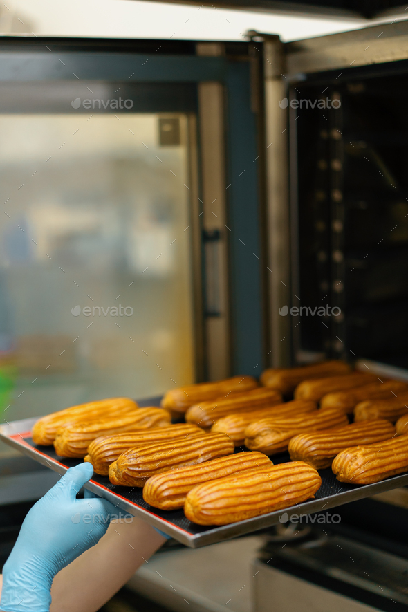 Kitchen in the bakery - ready-made eclairs are taken from oven Stock ...