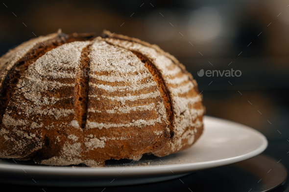 Close-up, bakery - freshly baked dark bread on rotating surface Stock ...