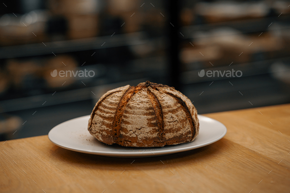 Close-up, bakery - freshly baked dark bread on rotating surface Stock ...
