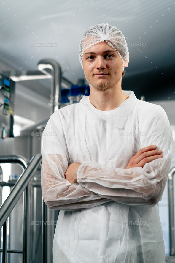 Portrait of a serious technologist in a special uniform standing at a ...