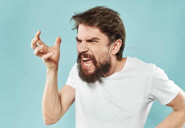 Aggressive man with a beard on a blue background cropped view Stock ...
