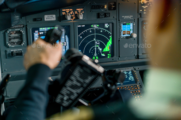 Pilot in airplane cockpit holding turning wheel rudder during flight ...