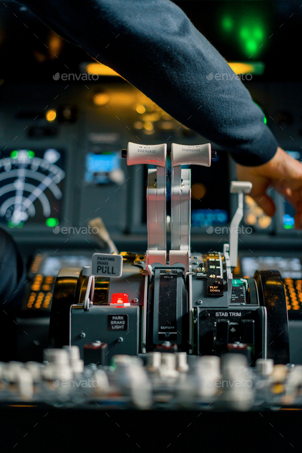 Close-up of a pilot's hand pressing the throttle in the cockpit of a ...